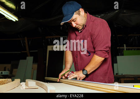 This is photo of professional carpenter at work measuring wooden planks ...