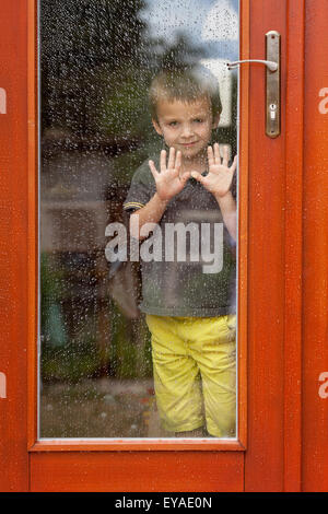 Boy child, rain and sad by window with thinking, mental health and ...