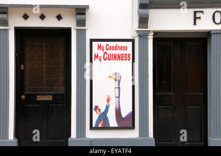 Irish pub with Guinness ad poster in both Gaelic and English, Kilkenny ...