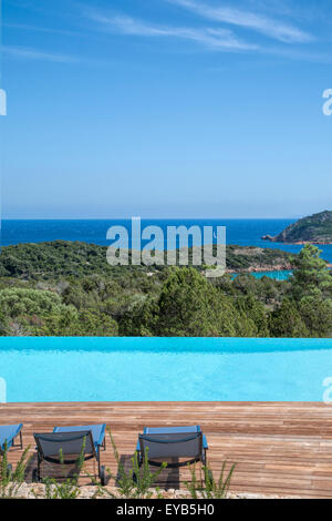 Infinity pool with recliners Stock Photo - Alamy