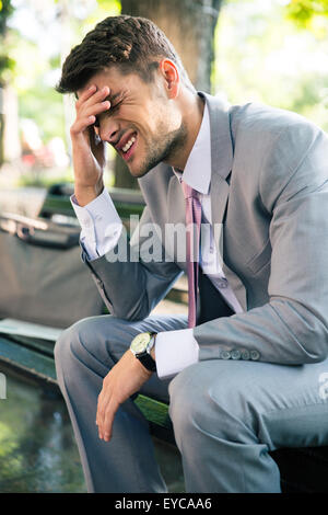 Young handsome businessman sitting on white cube Stock Photo - Alamy