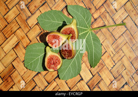 Figs halves on fig leaf set on wooden table Stock Photo - Alamy