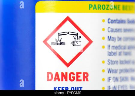 Hazard warning label on bottle of bleach sodium hypochlorite hydroxide ...