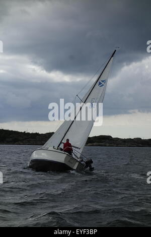 A man single handed sails Maxi 77 sailboat in the sea of Bohuslan ...