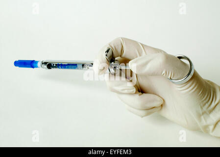 A novocaine carpule is inserted into a anesthetic syringe by a dentist ...