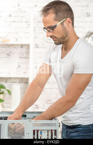 Young man repairing computer hardware in service center Stock Photo - Alamy