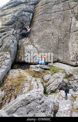 Children rock climbing on the granite tor of Haytor, Dartmoor national ...