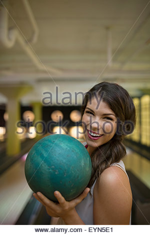 Young woman holding a bowling ball in a bowling alley Stock Photo - Alamy