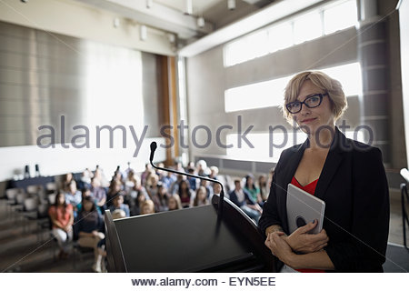 Portrait confident professor at podium in auditorium Stock Photo - Alamy