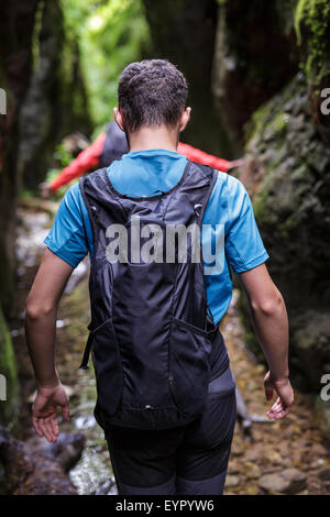 Back view of teenager walking with backpack and headphones isolated on ...