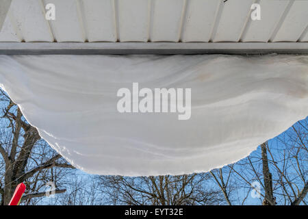 Deep snow drift overhanging on the roof of a house Stock Photo - Alamy