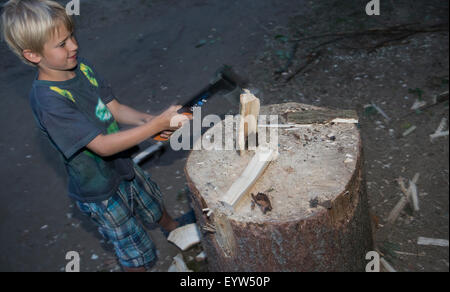 Child boy chopping wood alone, Splitting Logs Stock Photo - Alamy
