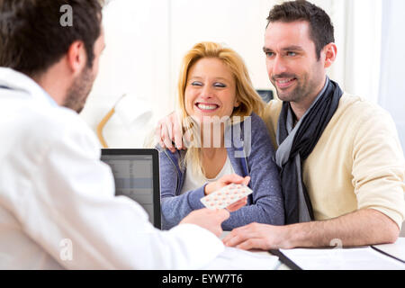View of a Doctor gives pills to couple of patient Stock Photo - Alamy
