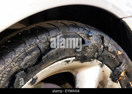 A melted tire and wheel on a car sits outside a home destroyed by Stock ...