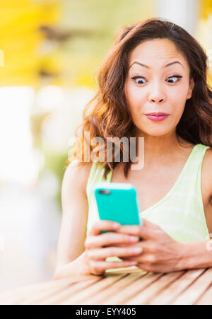 Chinese woman using cell phone on bed Stock Photo - Alamy
