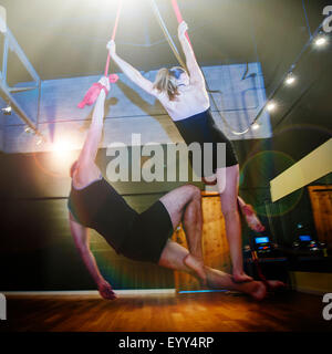 Caucasian acrobats hanging from ropes in studio Stock Photo - Alamy