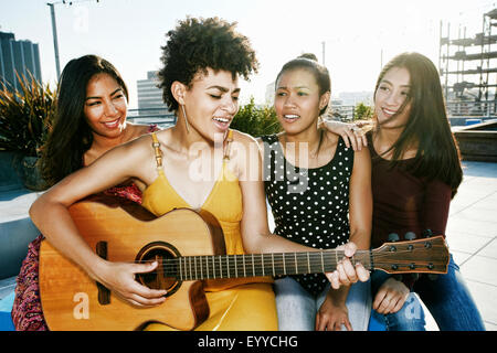 Young hispanic woman musician singing song playing ukulele at music ...