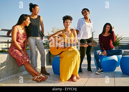Young hispanic woman musician singing song playing ukulele at music ...