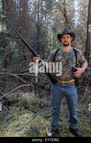 Portrait of man with gun in camouflage on paintball field Stock Photo ...