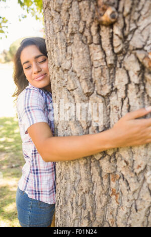 Pretty brunette hugging tree Stock Photo - Alamy