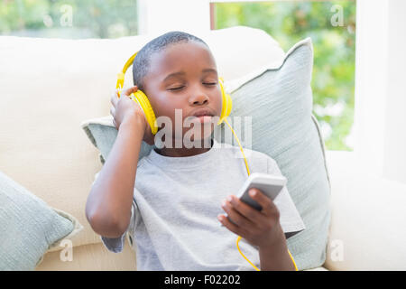 Little boy listening to music on the couch Stock Photo - Alamy