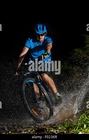 Mountain biker running through water Stock Photo - Alamy