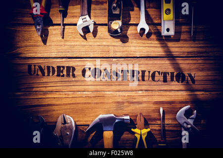 Under construction against desk with tools Stock Photo - Alamy