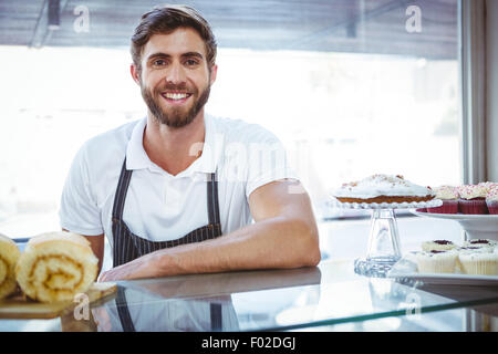 Smiling worker posing behind the counter Stock Photo - Alamy