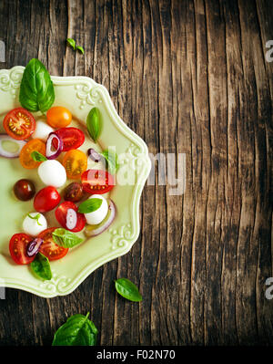 Caprese salad plate on wooden table Stock Photo - Alamy