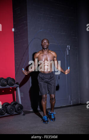 Sporty young man with jumping rope on grey background Stock Photo - Alamy