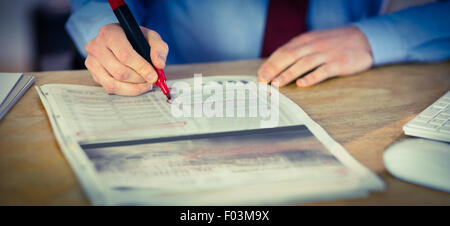 Businessman marking the newspaper with marker Stock Photo - Alamy