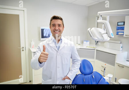 happy male dentist showing thumbs up at clinic Stock Photo - Alamy