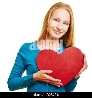 Blonde teenager woman holding red heart very happy pointing with hand ...