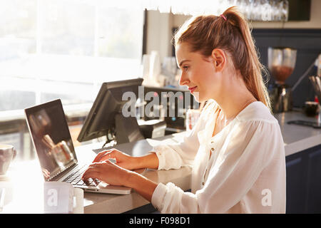 Female restaurant manager working at counter Stock Photo - Alamy