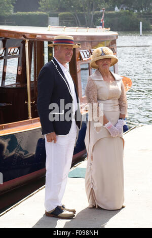 Elegant couple in vintage costumes posing at a vibrant themed party ...