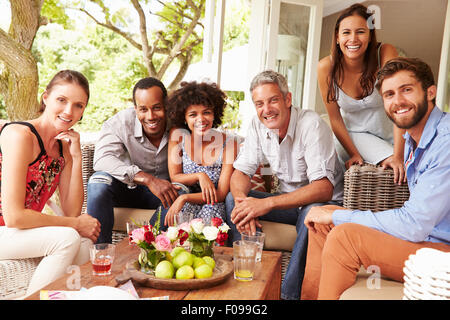 Group of friends socialising in a conservatory Stock Photo - Alamy