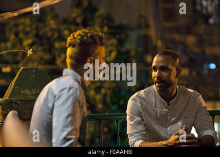 Two young men sitting at bar and talking Stock Photo - Alamy