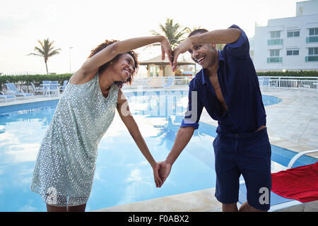 Couple making heart shape with arms on Arpoador beach, Rio De Janeiro ...