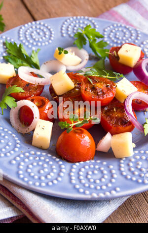 Salad with tomato and halloumi cheese on wooden table Stock Photo - Alamy