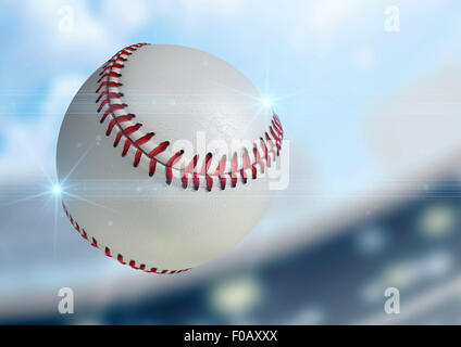 A regular baseball ball flying through the air on an a outdoor stadium ...