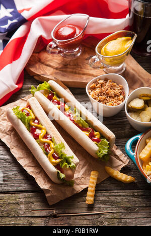 Tasty hot dogs with USA flag, cola and mustard on red background ...