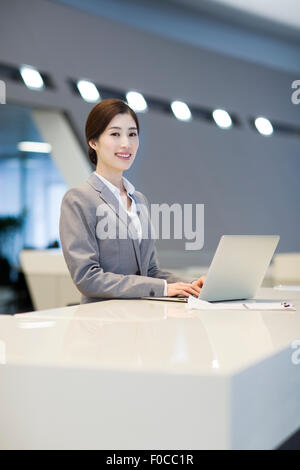Asian reception worker using white screen on computer while working at ...