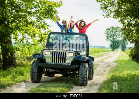Excited women having fun on a jeep Stock Photo - Alamy
