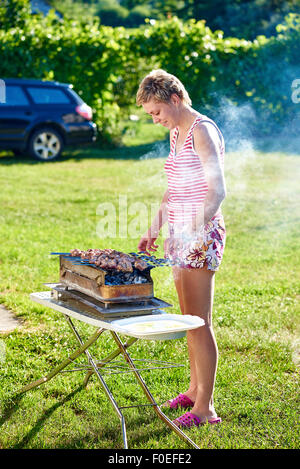Pretty girl cooking barbecue outdoors Stock Photo - Alamy