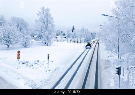 Midwinter traffic on snowy streets, roads up North. Overcast weather ...