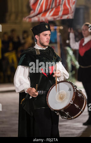 man in medieval dress, purple shirt and helmet holds a bow. the irony ...