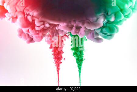 Red and green ink making clouds in water Stock Photo - Alamy