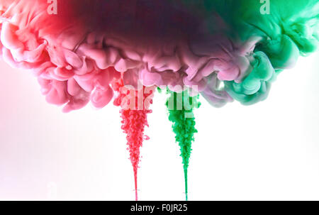 Red and green ink making clouds in water Stock Photo - Alamy