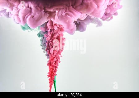 Red and green ink making clouds in water Stock Photo - Alamy