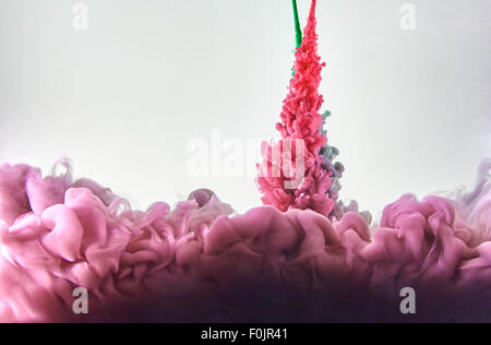Red and green ink making clouds in water Stock Photo - Alamy